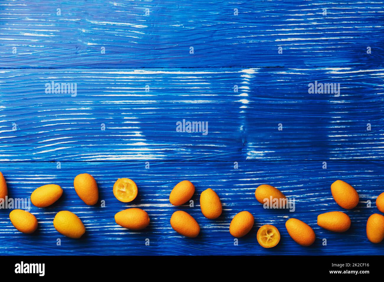 Light blue flat lay with top view on fresh ripe kumquat citrus fruits ...