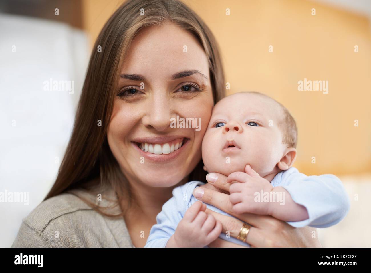 Isnt he cute. A young mother holding her newborn baby Stock Photo - Alamy
