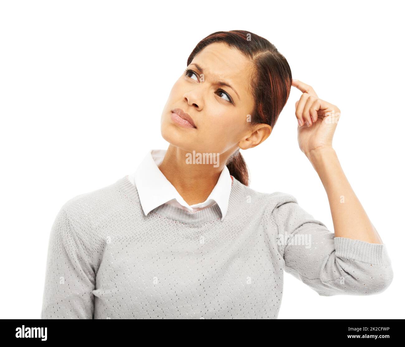 That one is a thinker.... Studio shot of a young woman scratching her ...