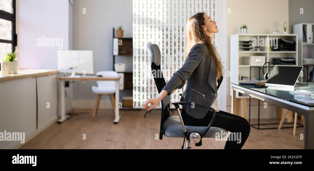 Employee Stretching At Office Desk Stock Photo - Alamy