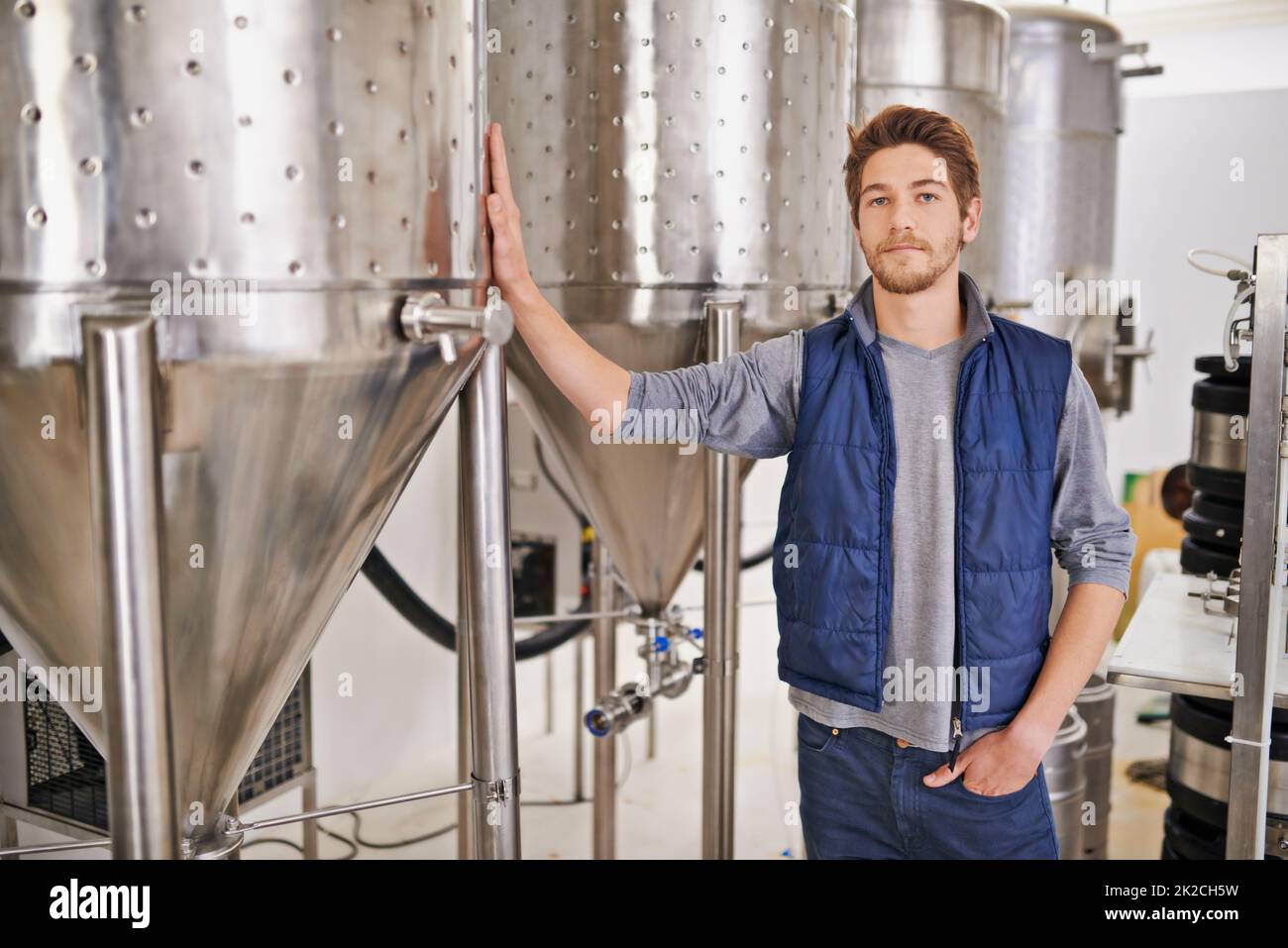 These tanks a holding the finest of beers. Portrait of a man working in ...