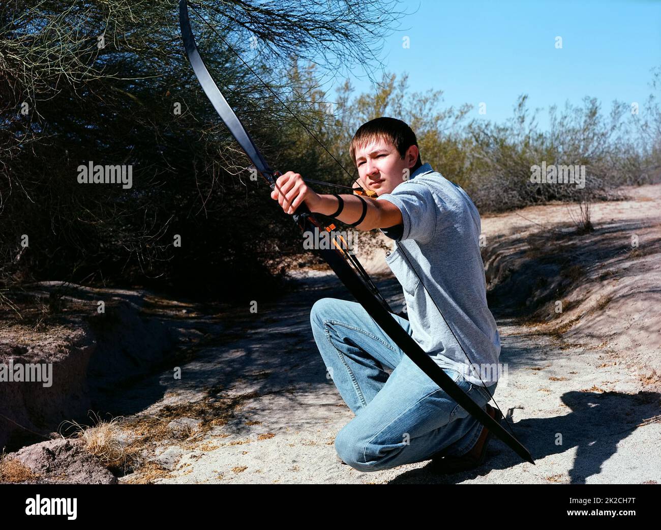 The Traditional Archer shooting a long bow in the desert Stock Photo ...