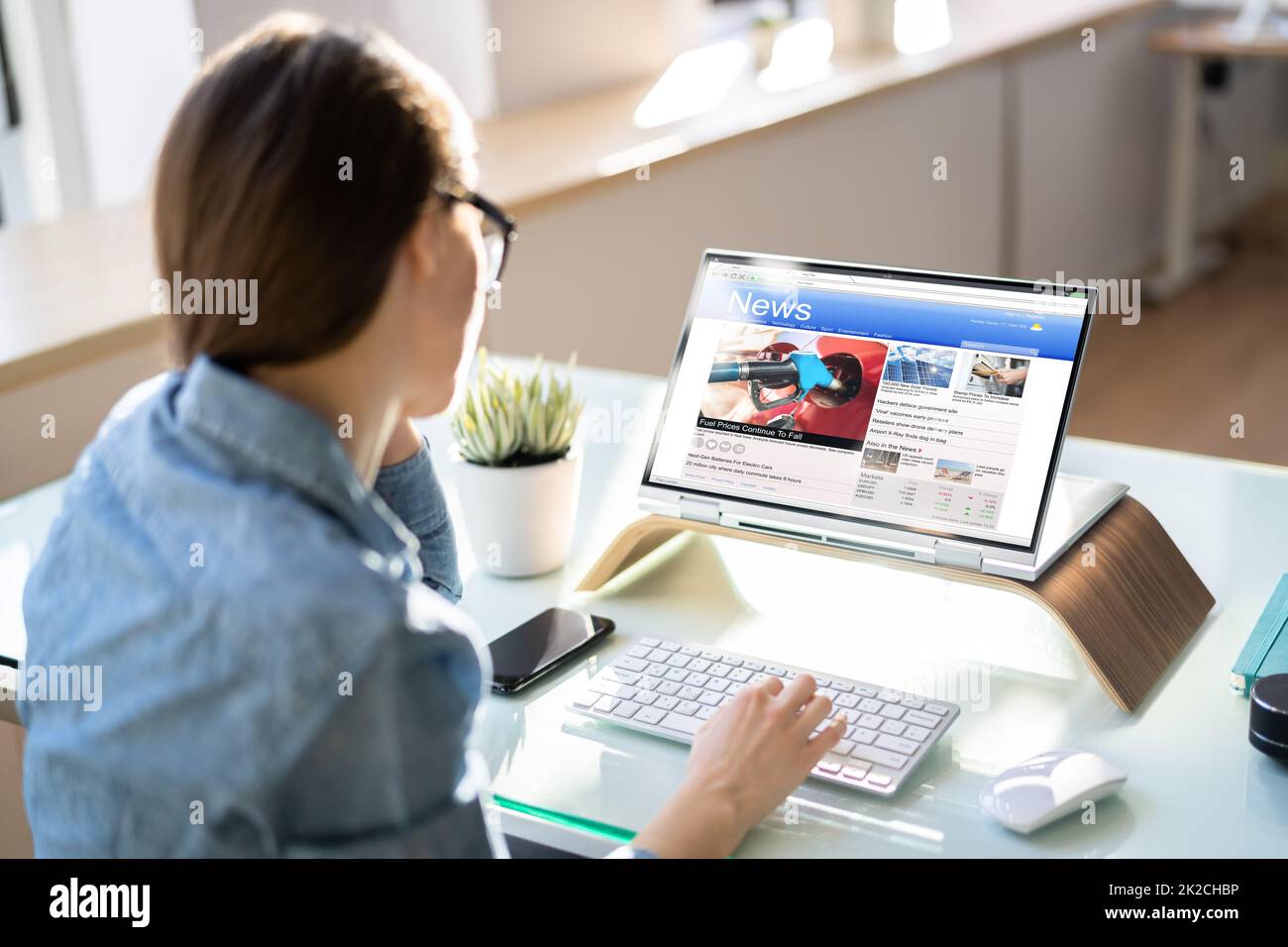 Woman reading newspaper on computer hi-res stock photography and images ...