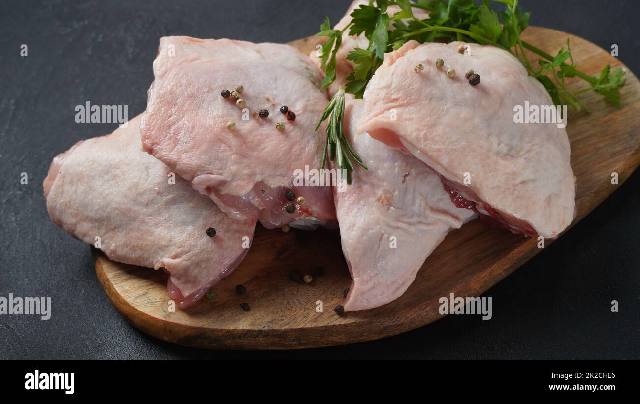 Raw chicken thigh on cutting board with spices Stock Photo - Alamy