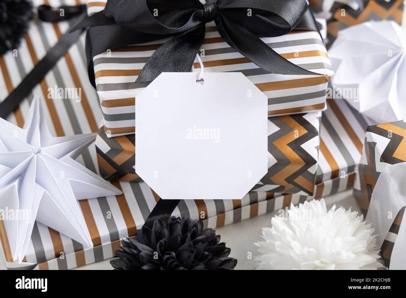 Wrapped present with blank gift tag and black bow close up, label ...