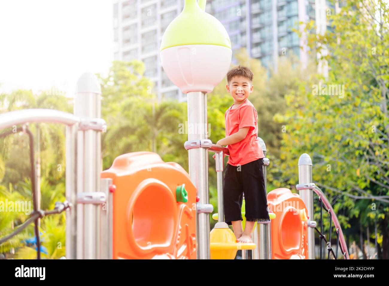 child playing on outdoor playground, happy preschool little kid having funny while playing on ...