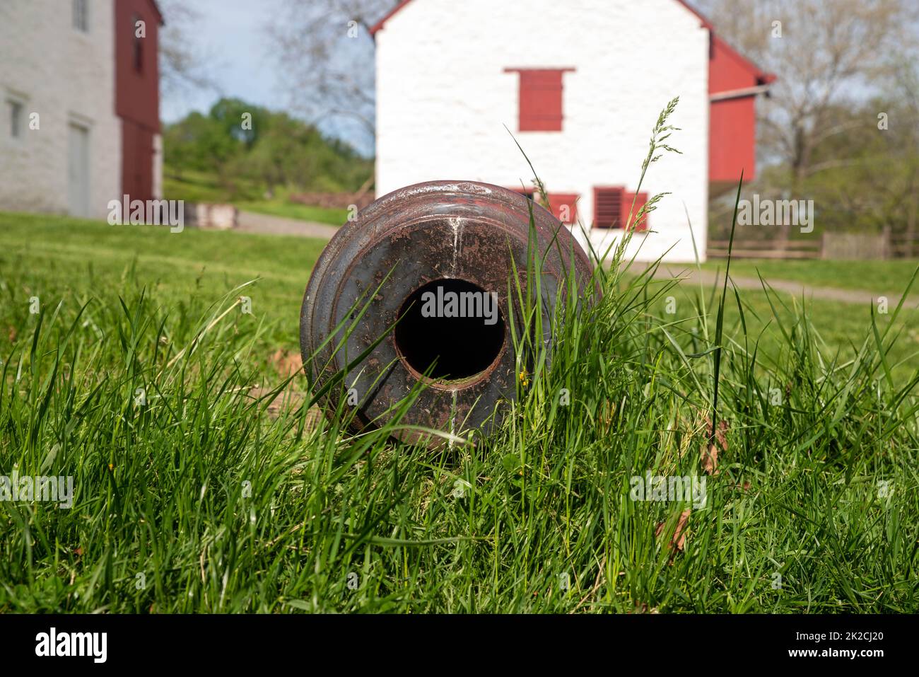 Down the barrel of a colonial cannon in the grass at iron forge Stock ...