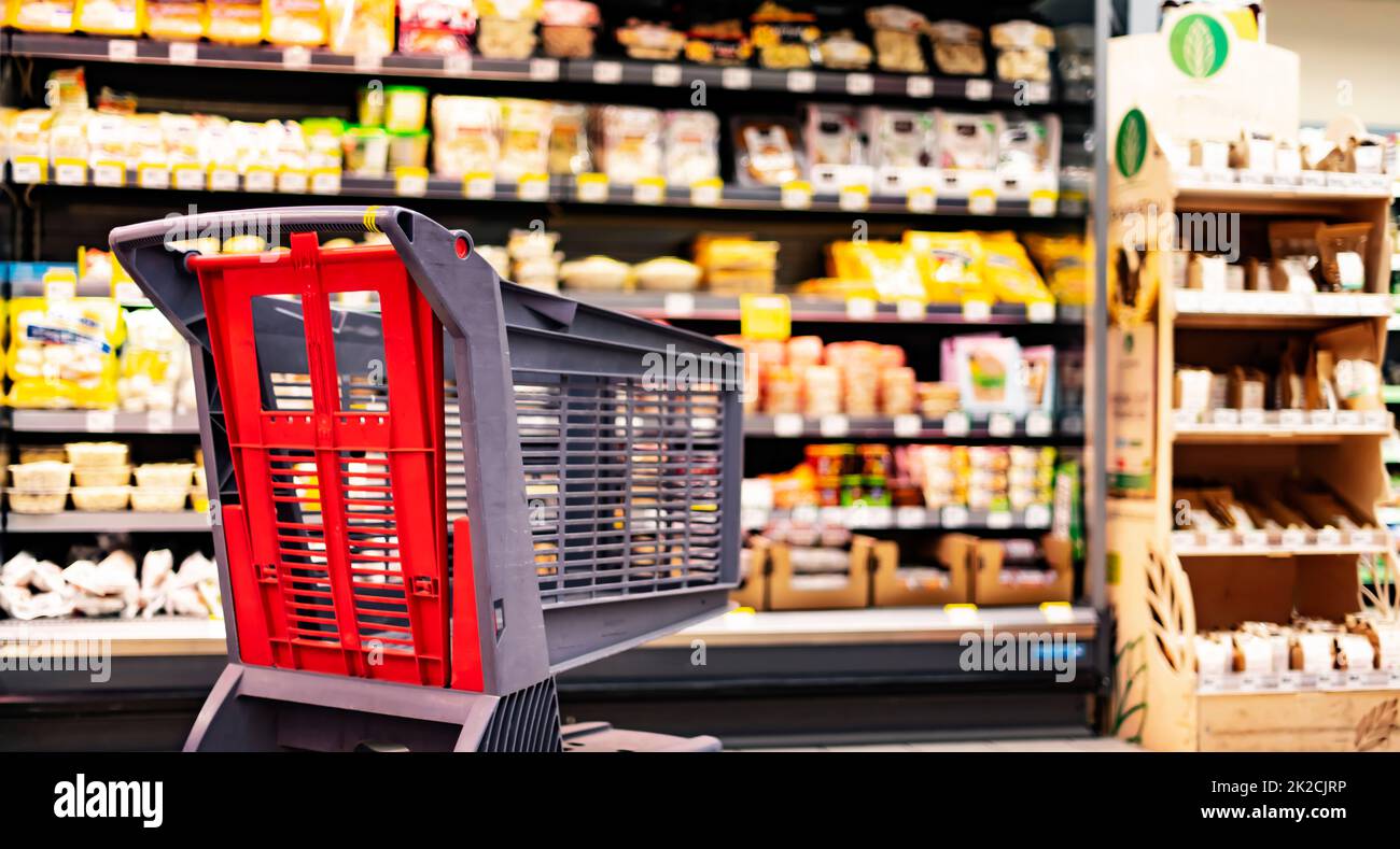 A shopping cart by a store shelf in a supermarket Stock Photo - Alamy