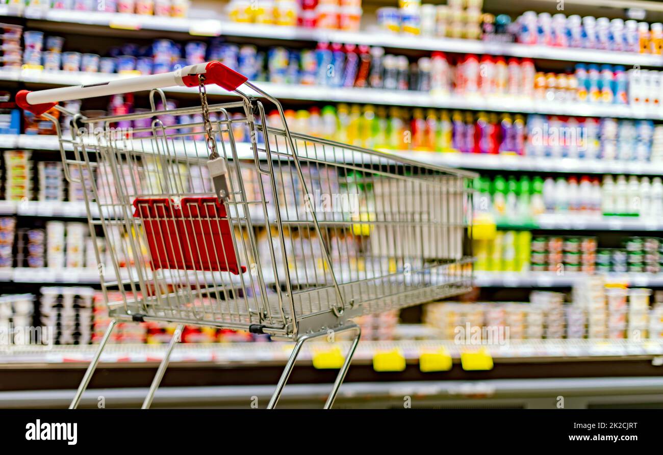A shopping cart by a store shelf in a supermarket Stock Photo - Alamy