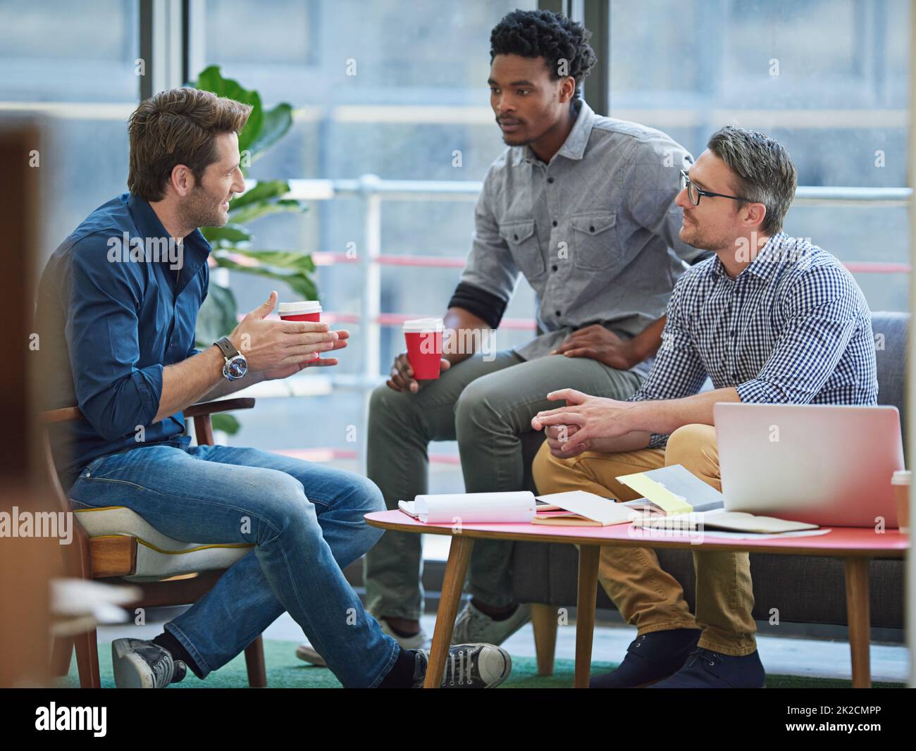 Lets bring this into focus. a group of office workers talking together ...