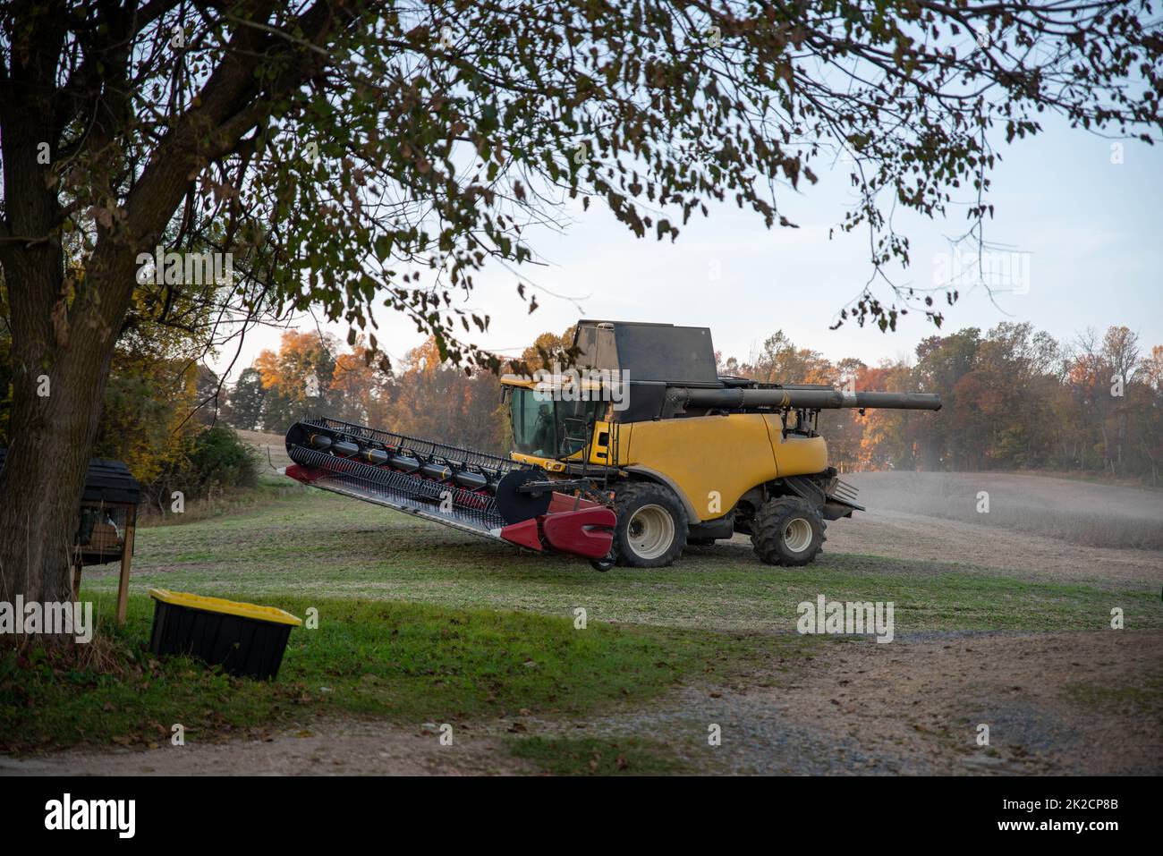 Combine harvester on freshly cut agricultural field fall woods ...