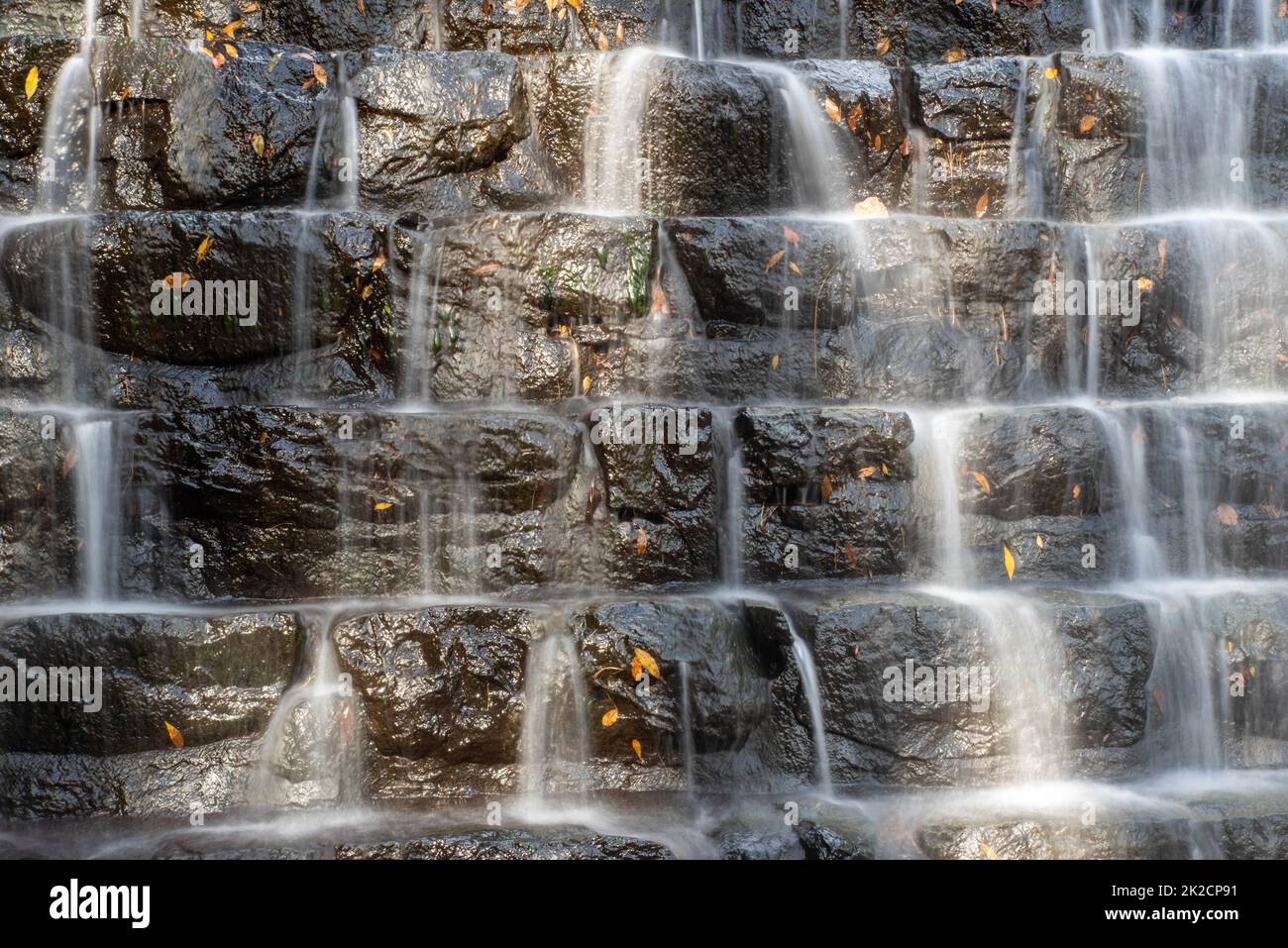 Water cascades over black rocks in tiered waterfall Stock Photo - Alamy