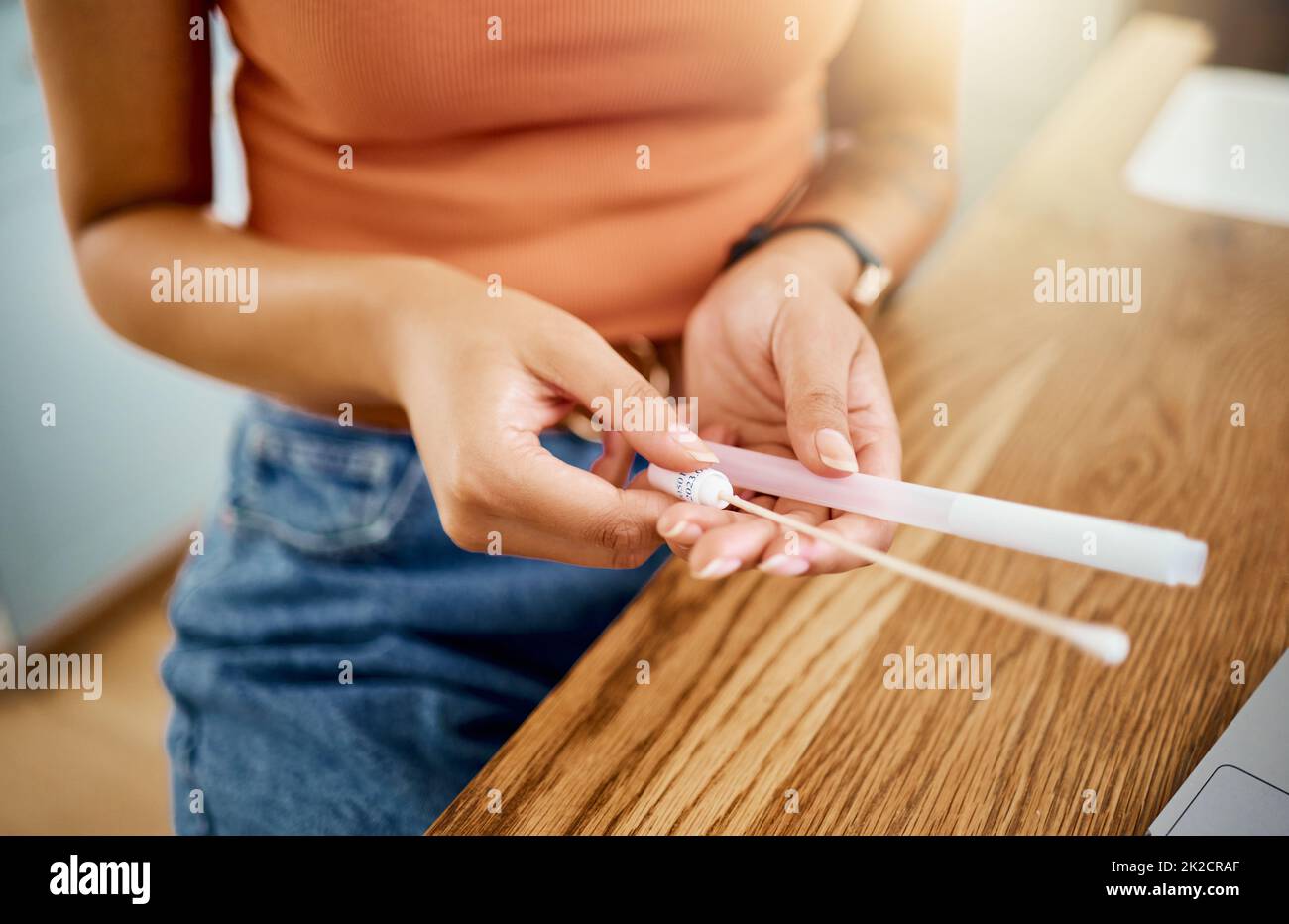 Woman with kit for covid test in hand at desk, to analyse results and ...