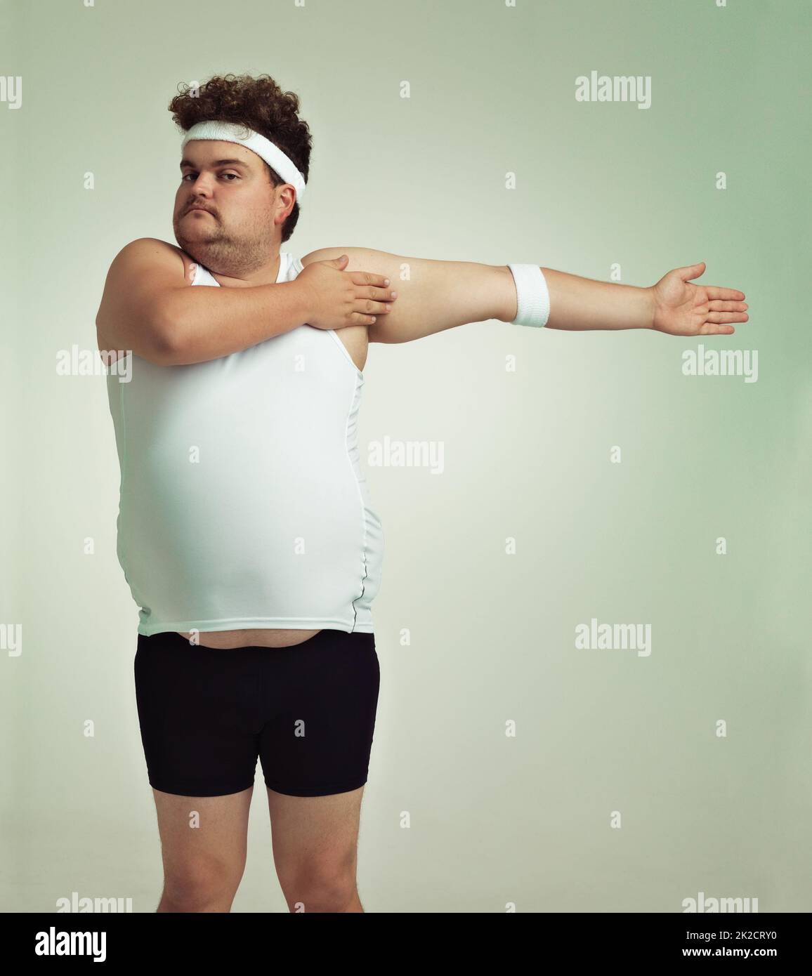 Stretching is important. Overweight man doing arm stretches Stock Photo ...