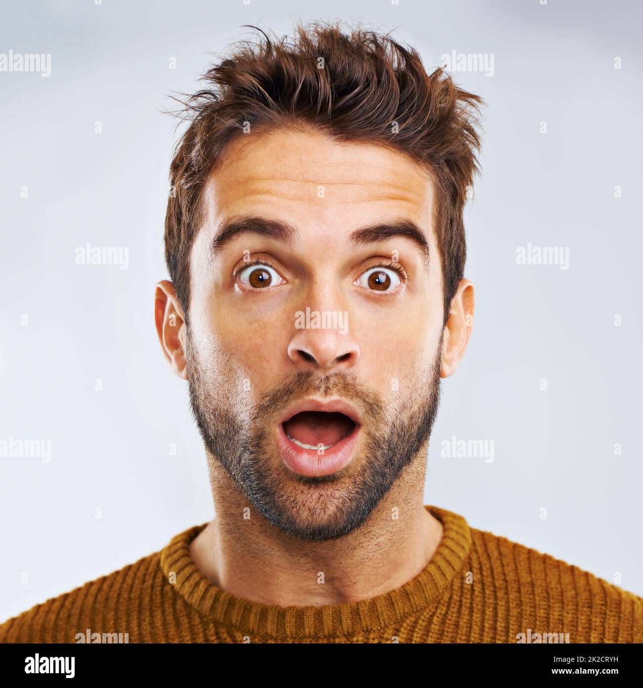 What just happened. Portrait of a shocked young man against a gray ...