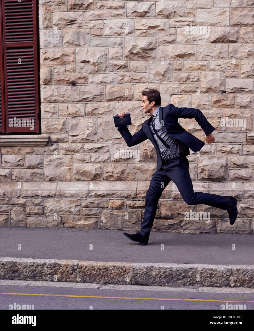 Im late. Shot of a young businessman running down a street Stock Photo ...