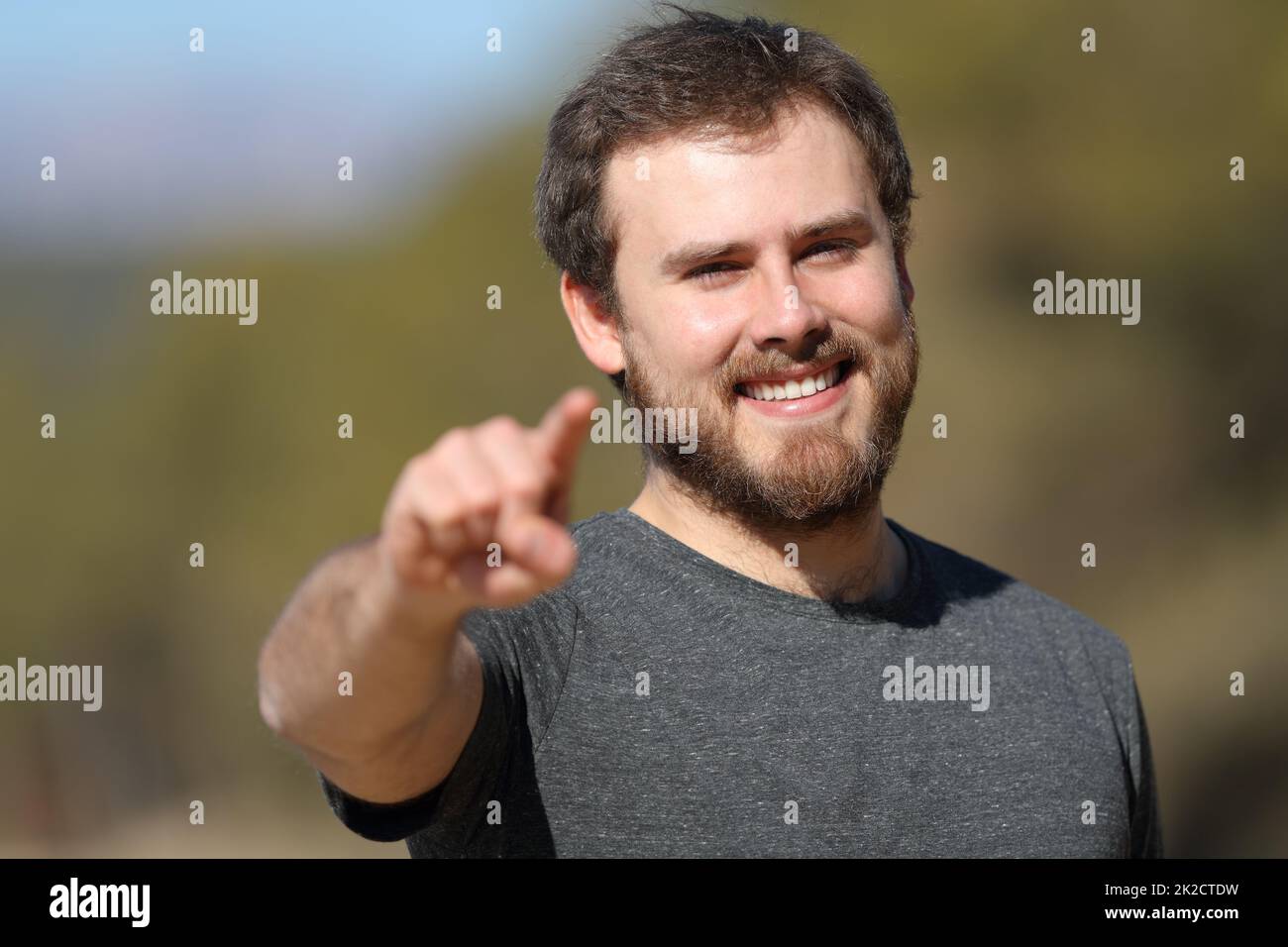 Happy man pointing at camera with forefinger in nature Stock Photo - Alamy