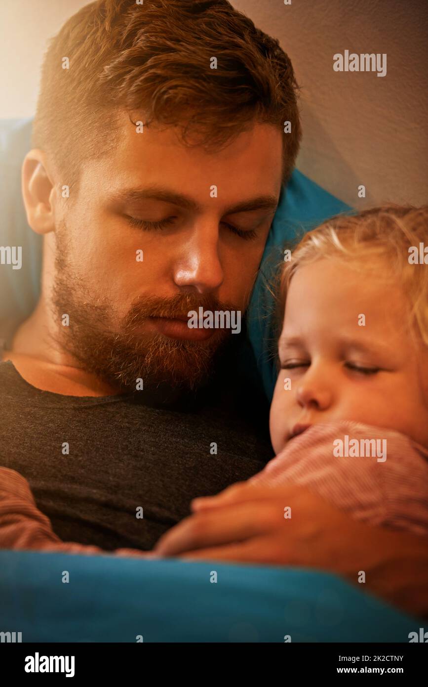 Sweet dreams, my little girl. A little girl asleep in her fathers arms in bed Stock Photo - Alamy