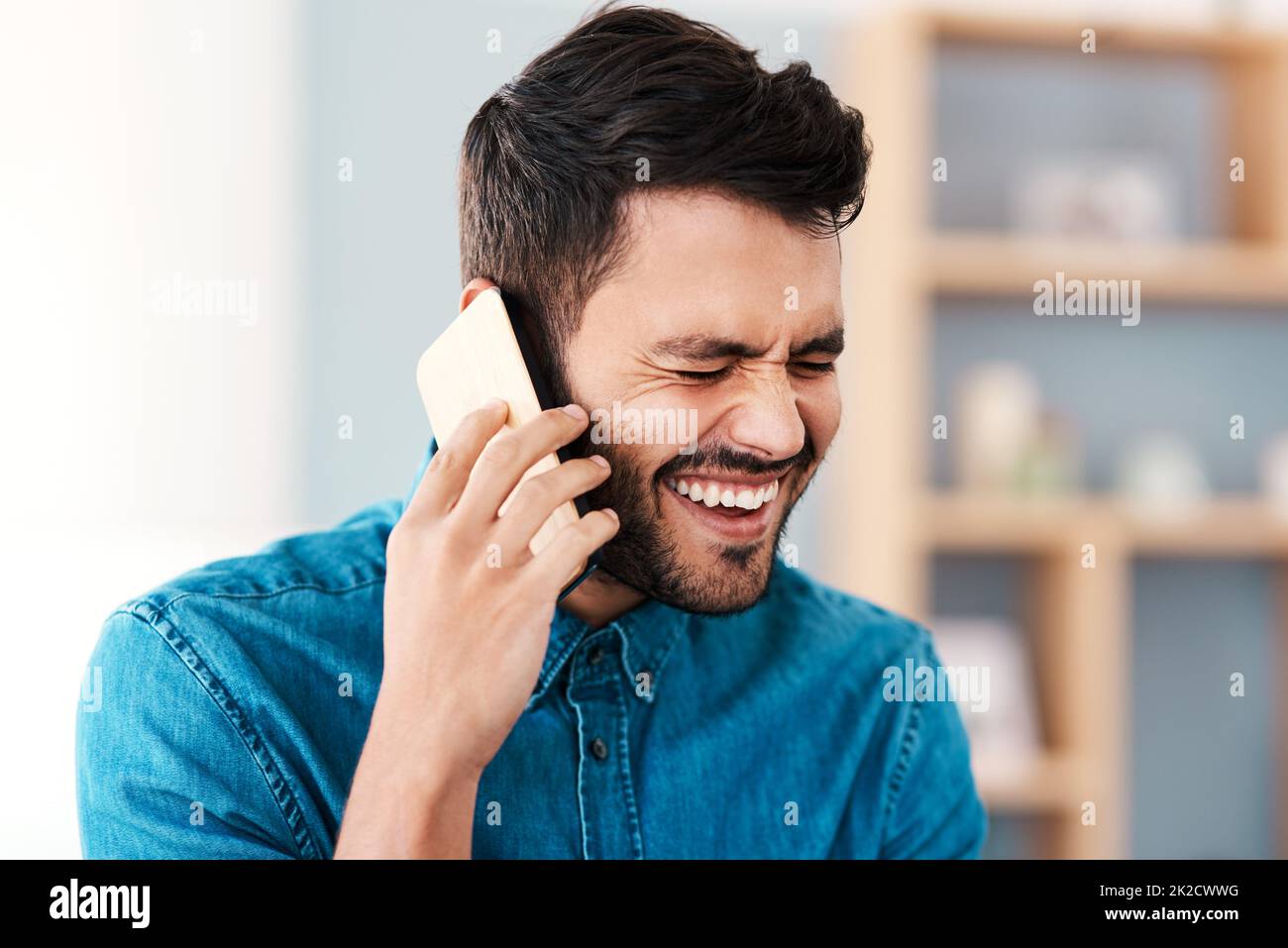 Laughing young man holding smartphone hi-res stock photography and ...