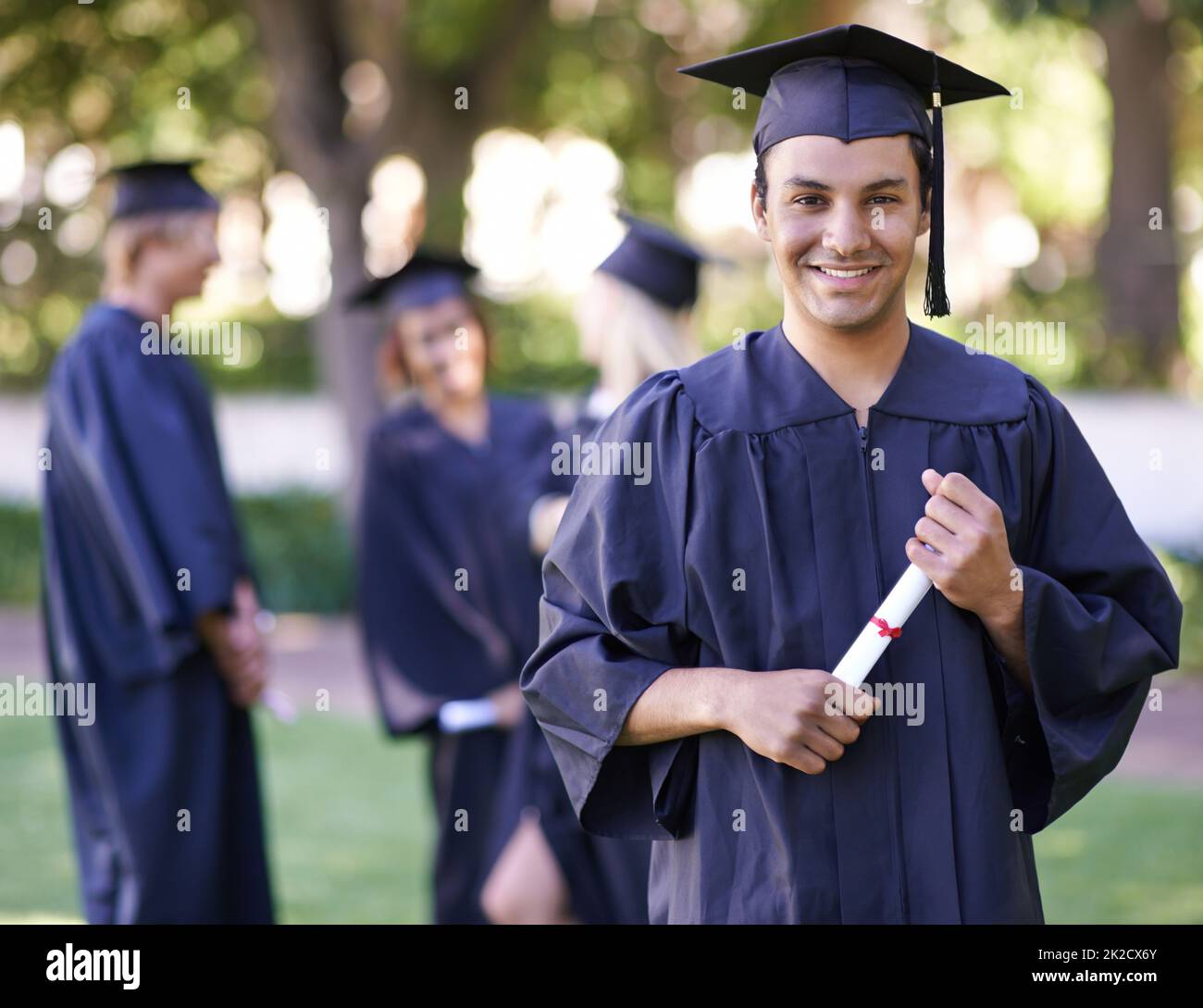 Excited about his future. Portrait of a smiling graduate holding his ...
