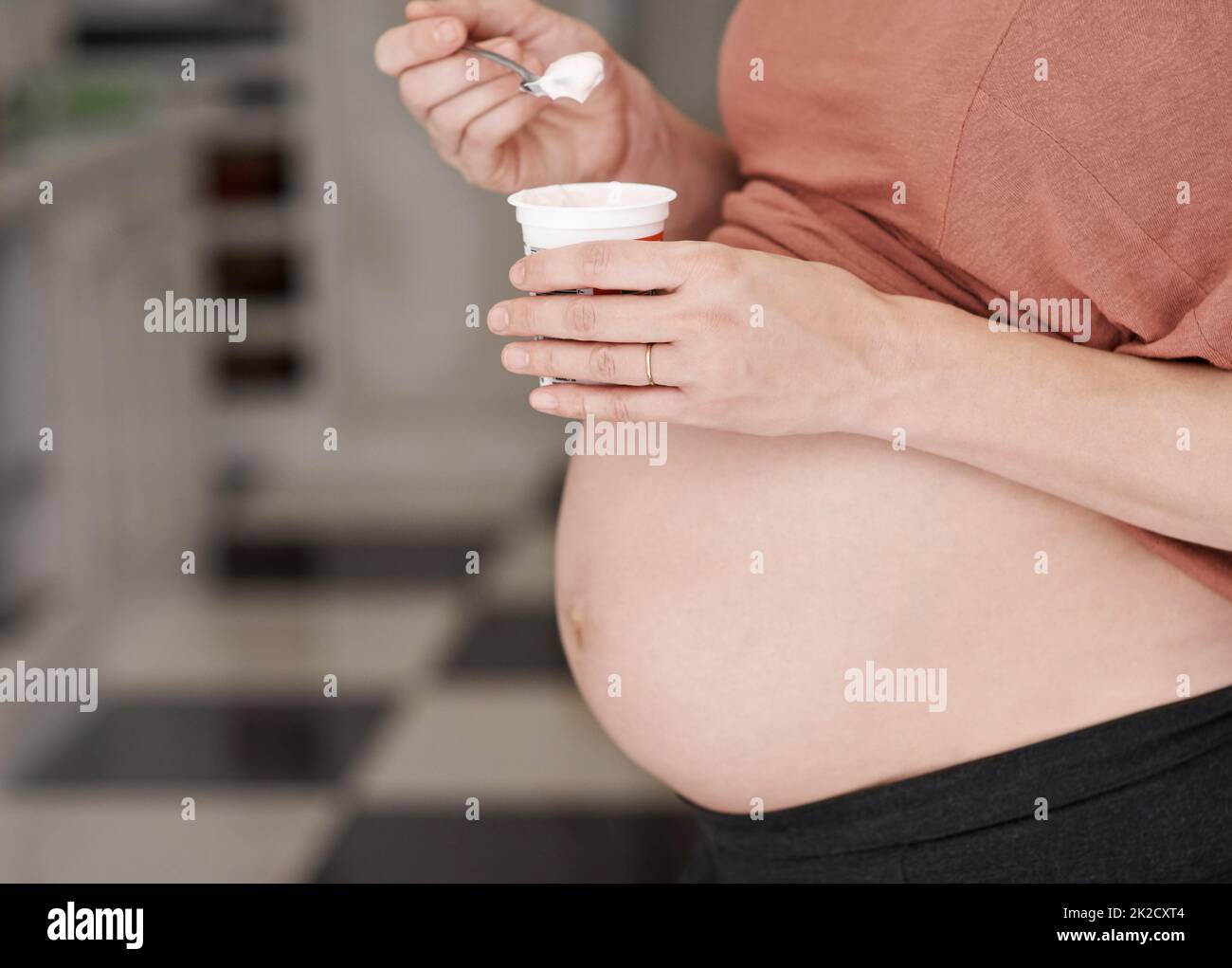 Its a very healthy snack. Cropped shot of a young pregnant woman eating ...