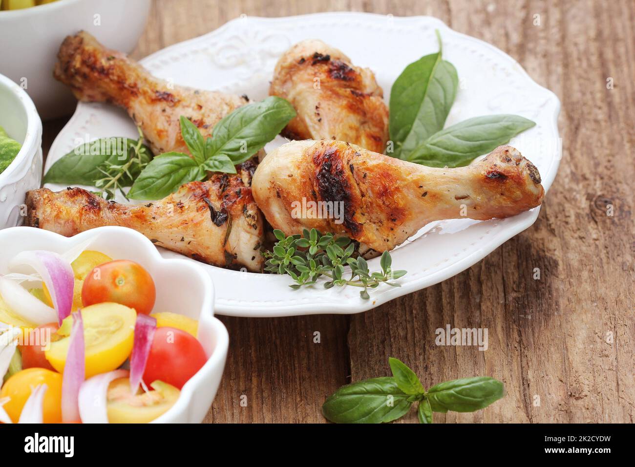 Grilled chicken legs with rosemary served on white plate. Dinner ...