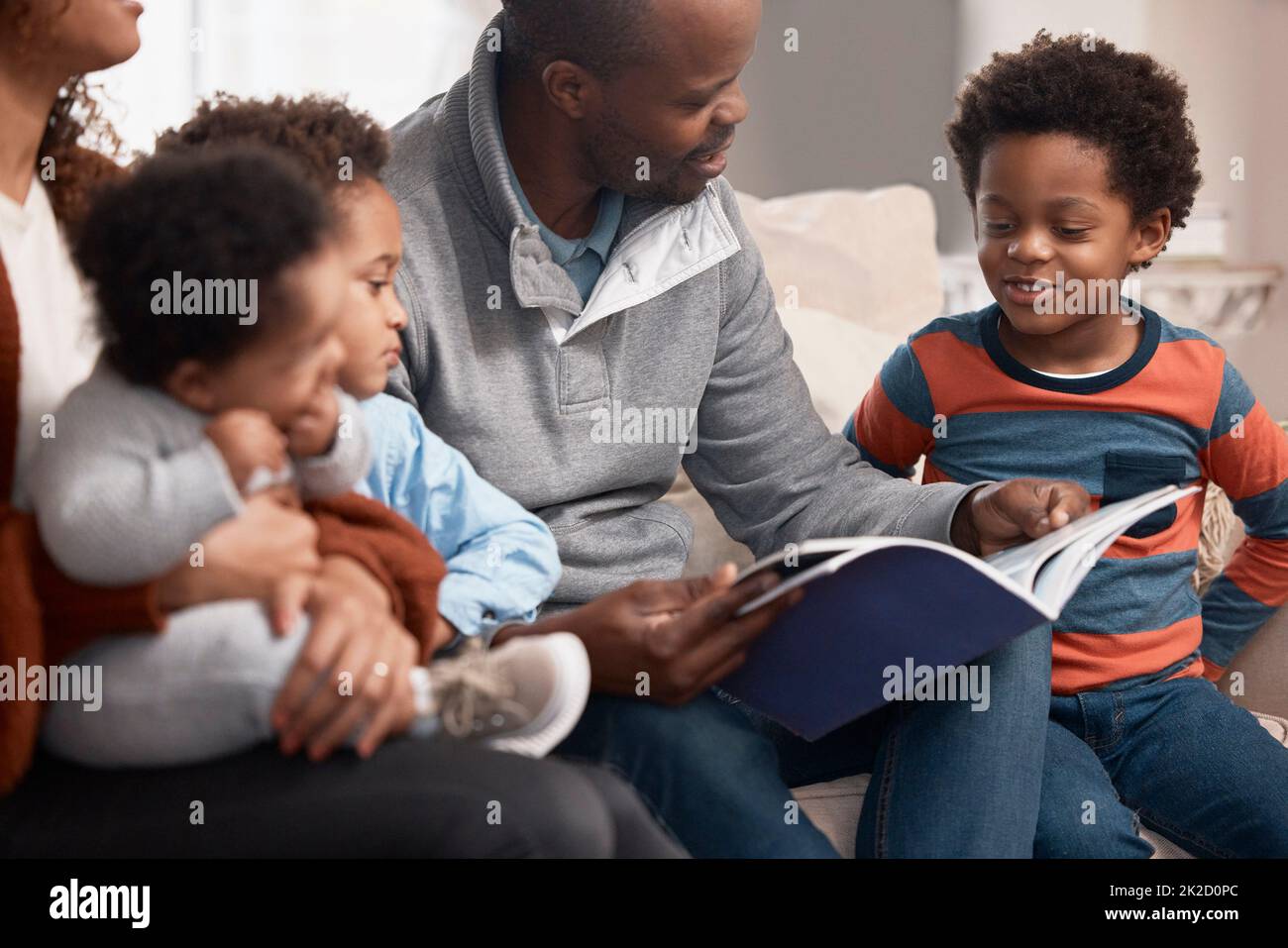 Family reading book at home hi-res stock photography and images - Alamy