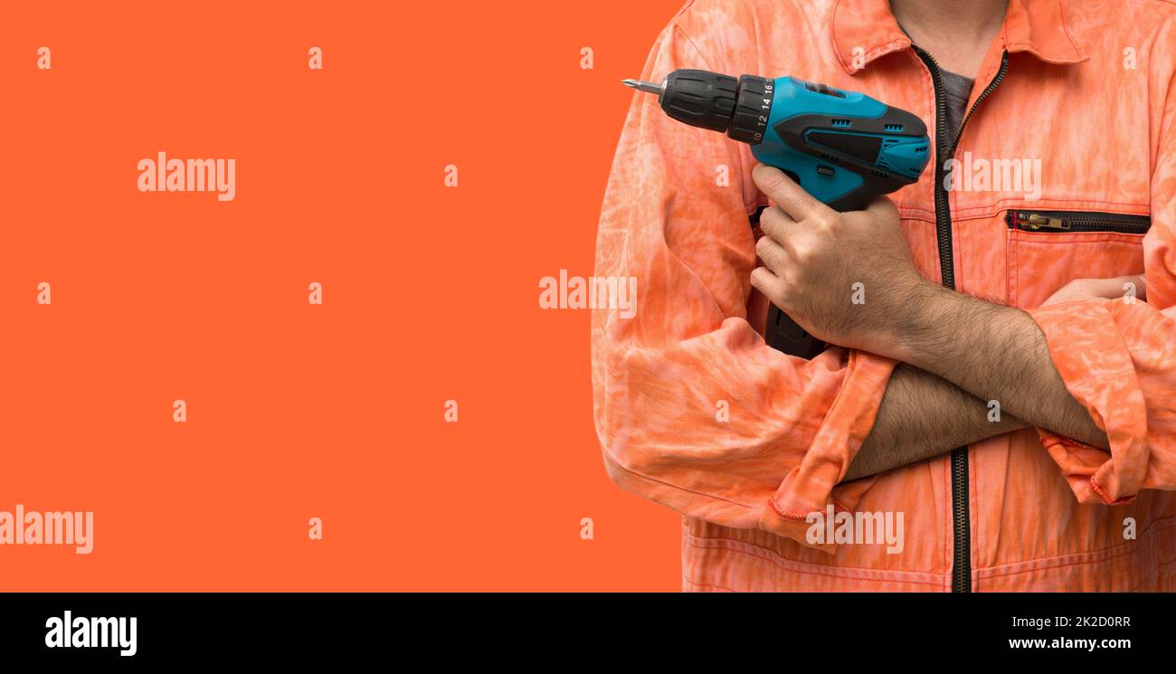 Chief mechanic wearing an orange uniform dress holding blue electric ...