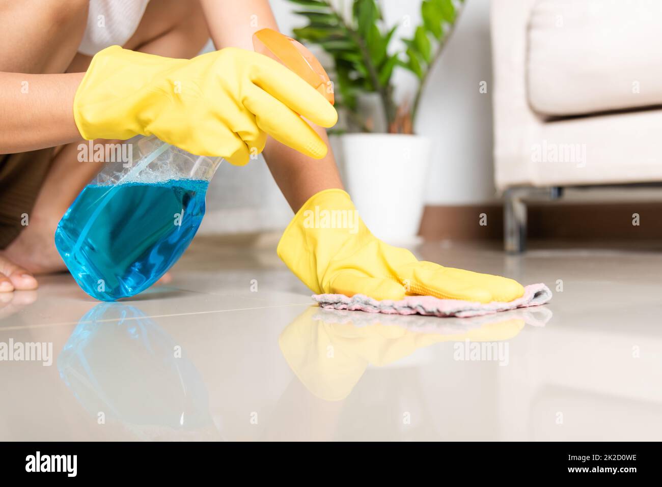 Asian woman wearing yellow rubber glover with cloth rag and detergent ...