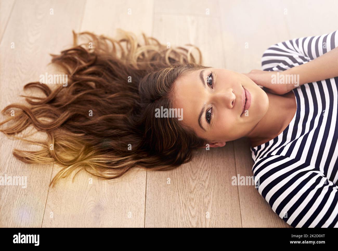 Let your hair down. High angle portrait of a young woman lying on her ...