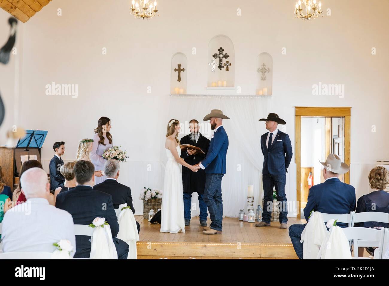 Bride and groom in cowboy hat at church altar on wedding day Stock ...