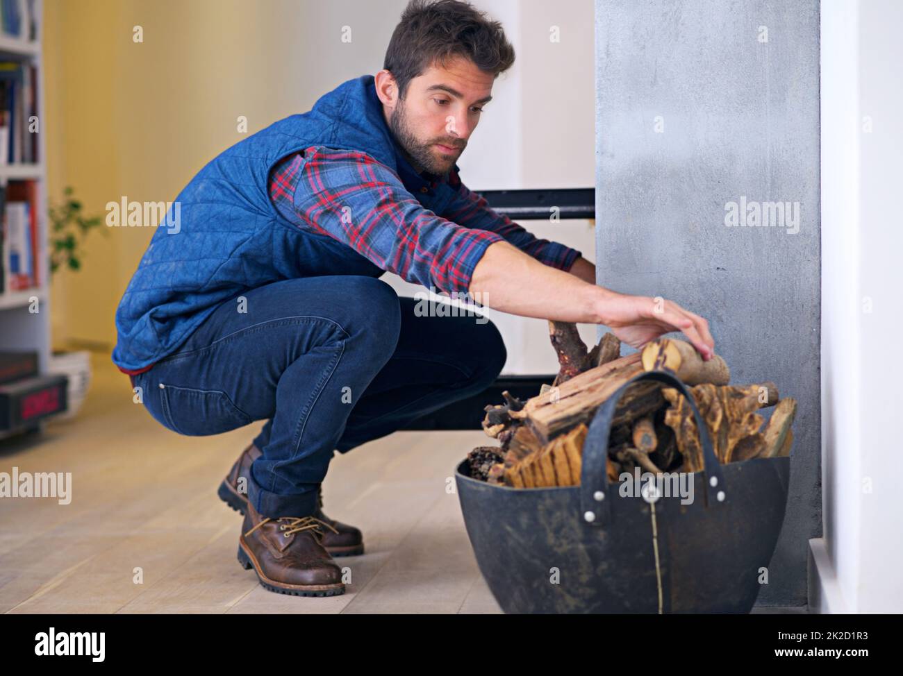 Ready for the winter. a young man building a fire in his fireplace at ...