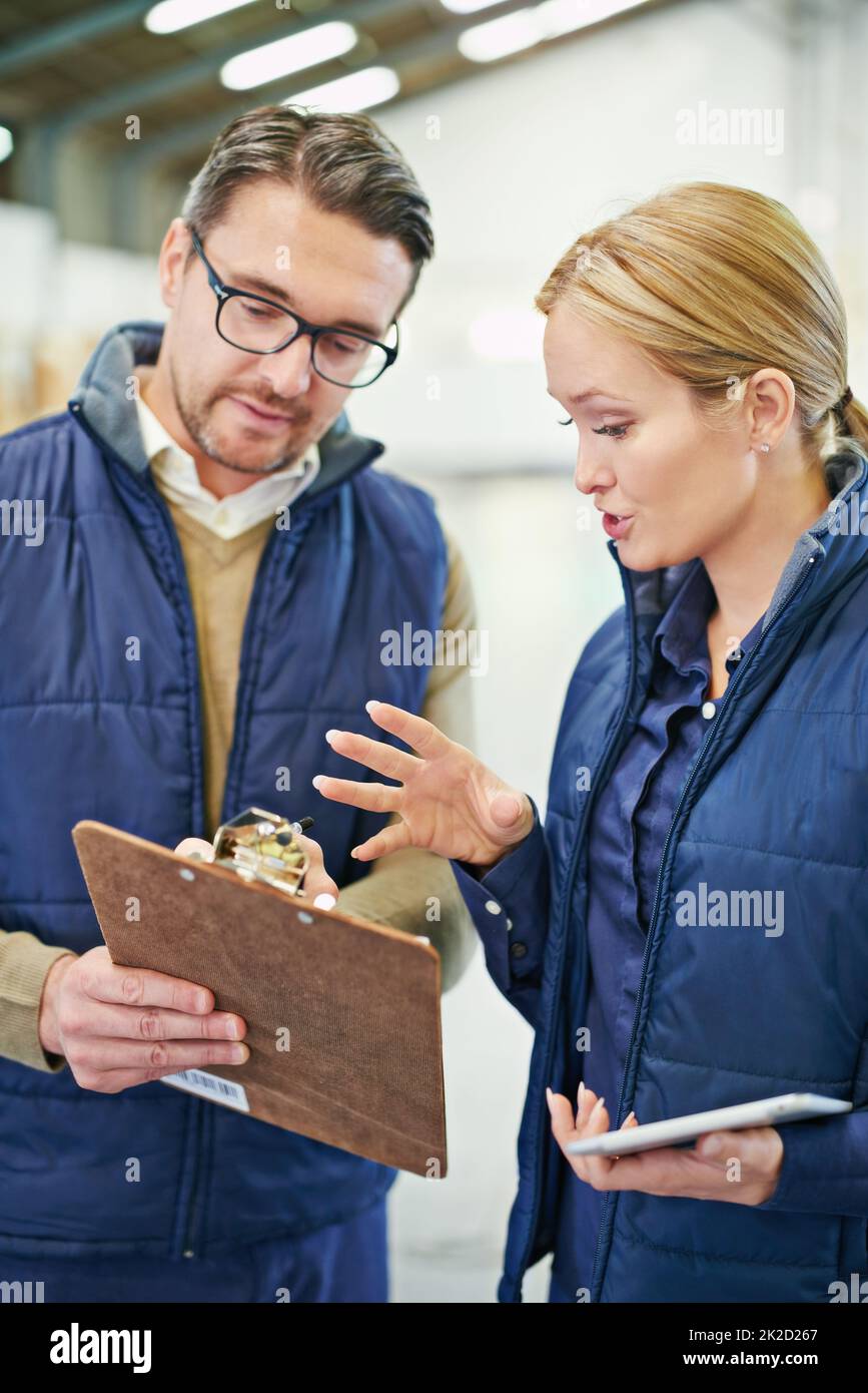 Comparing their paperwork. two people looking at paperwork while ...