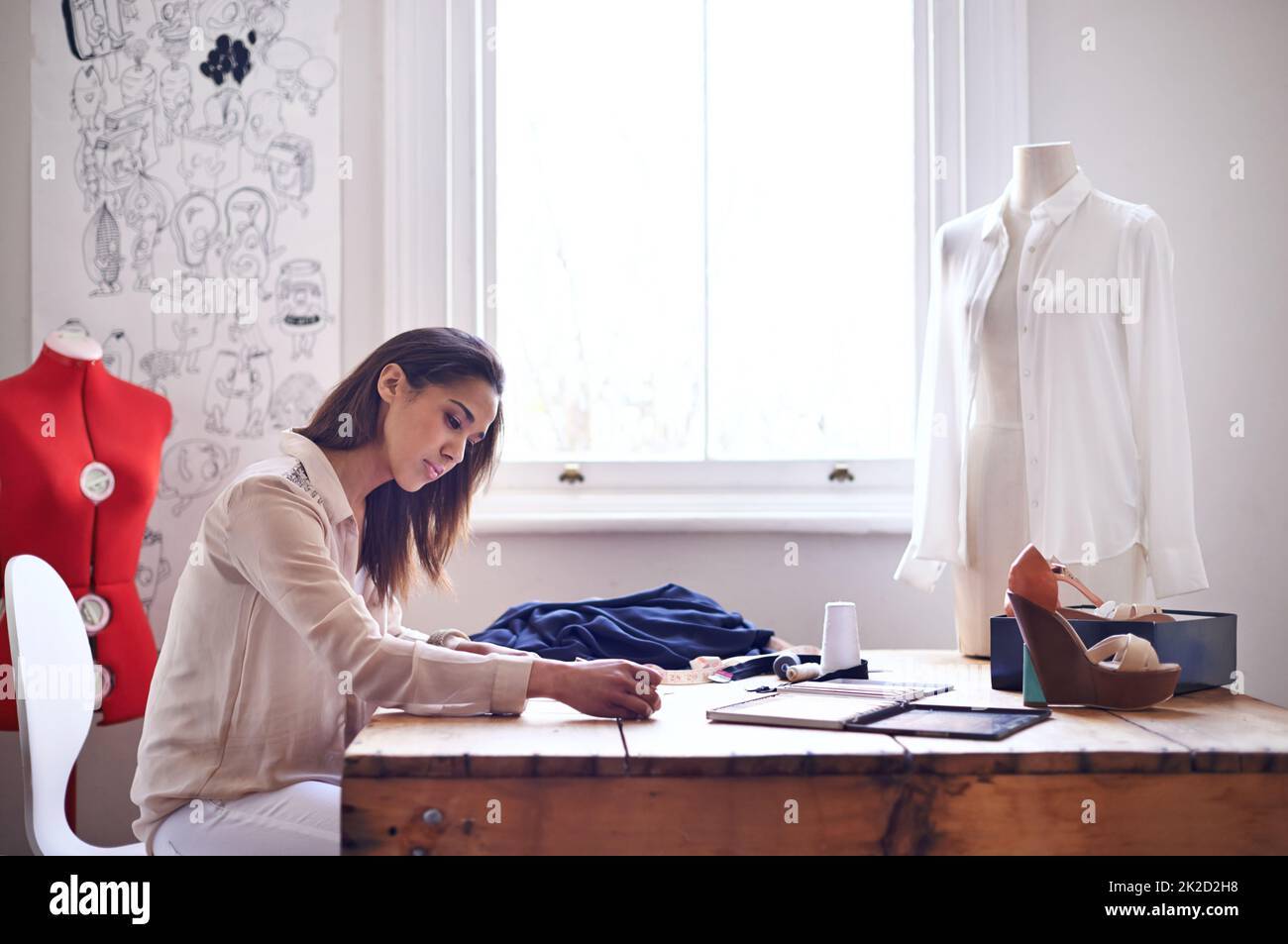 Creating this seasons trends. A fashion designer creating sketches in ...