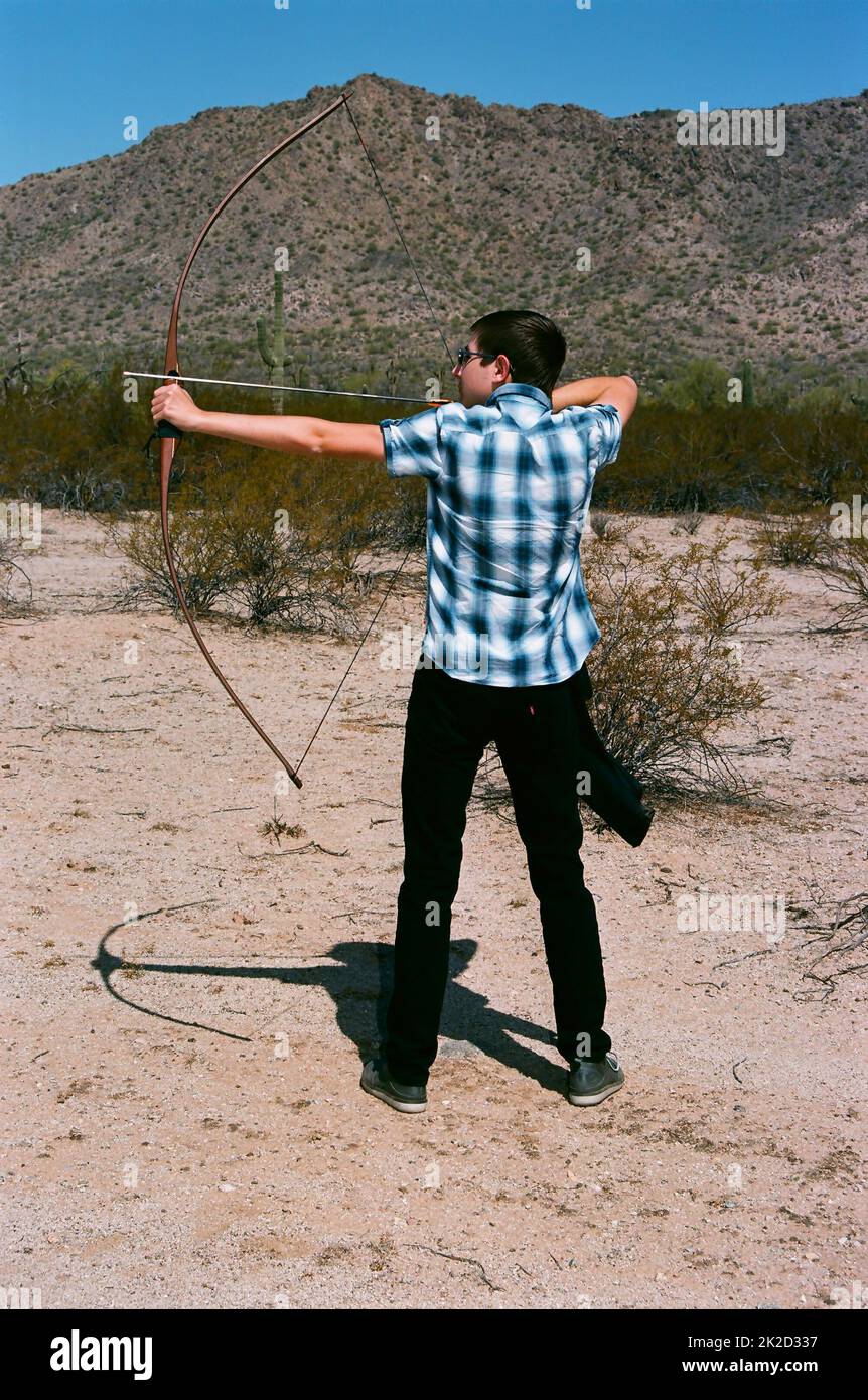 Young boy shooting a traditional long bow Stock Photo - Alamy
