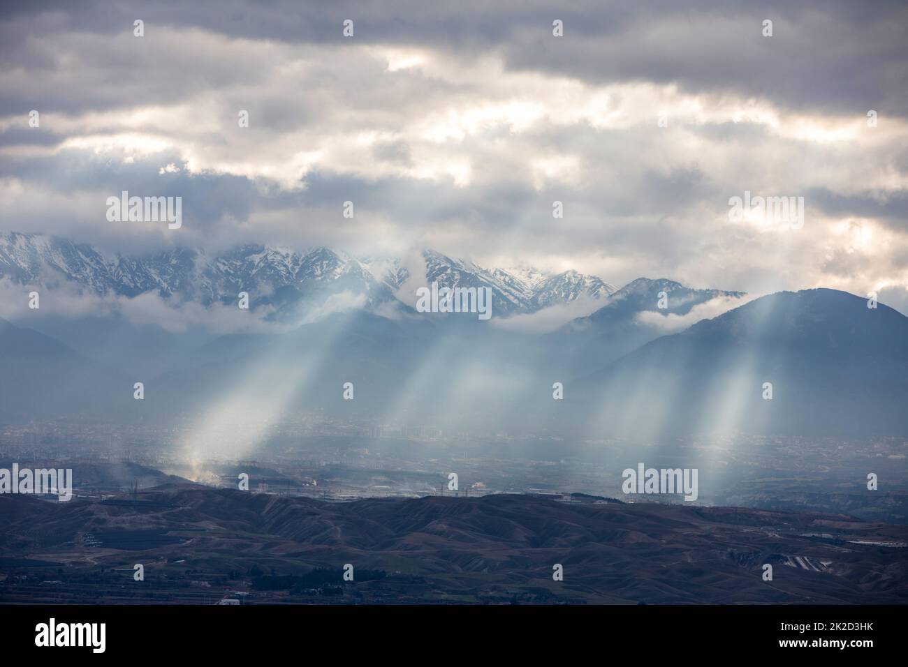 Sun light piercing through the clouds and hitting the mountains Stock ...