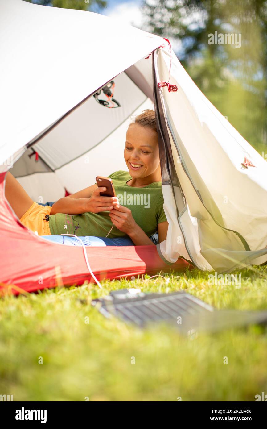 Cell phone charging with a solar charger in a tent during an outdoor ...