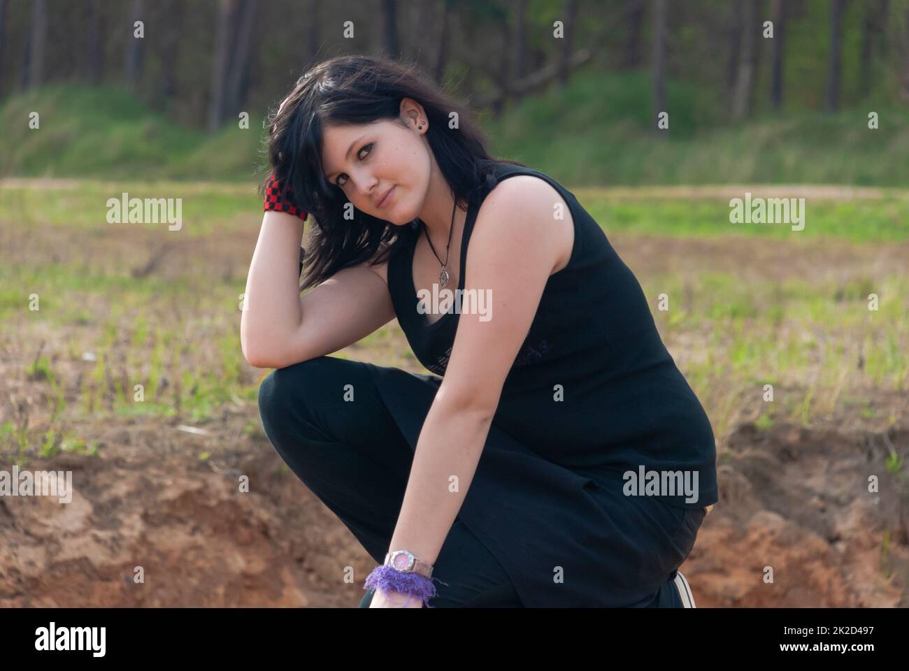 Punk emo girl, young adult with black hair, kneeling, looking at camera ...