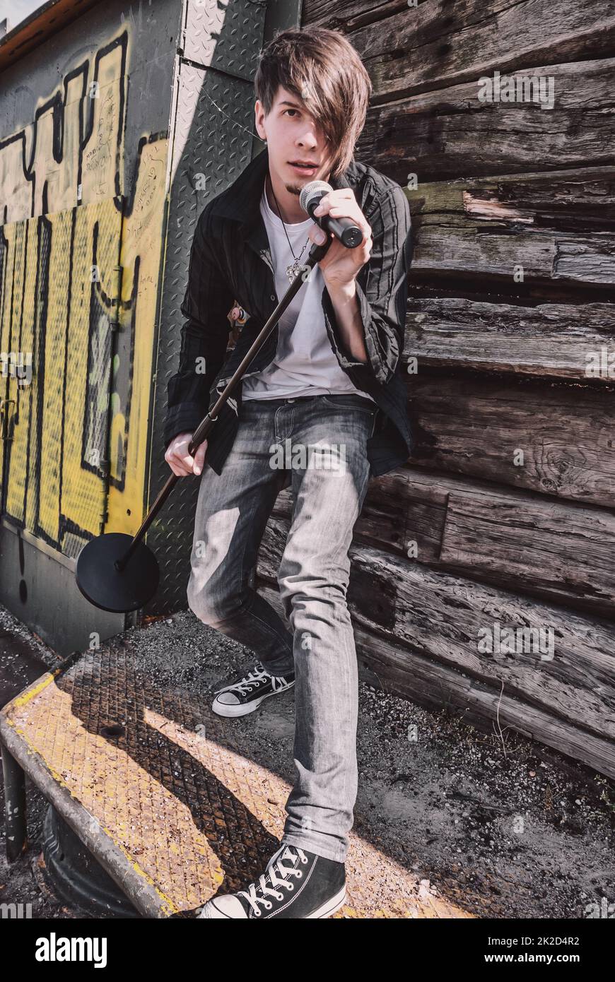 Singer, rock musician performing with microphone outdoors Stock Photo ...