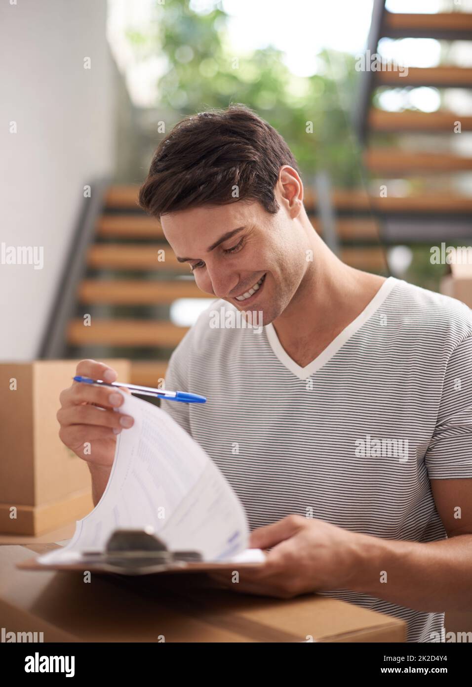 Got all my boxes - ready to move in. A happy young man signing for a ...