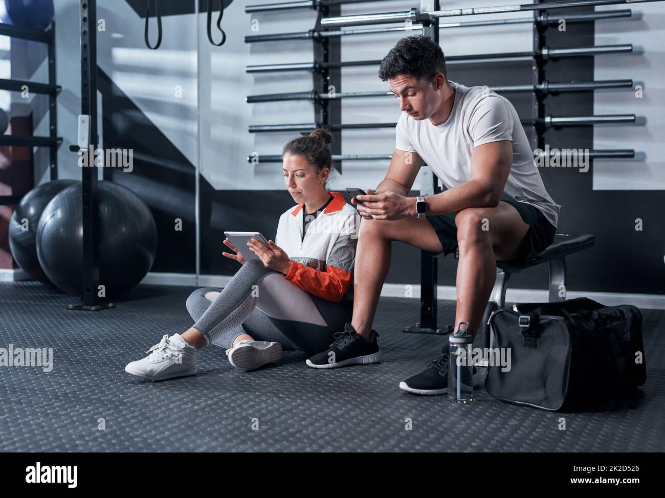 Taking a break with their connections. Shot of two sporty young people ...