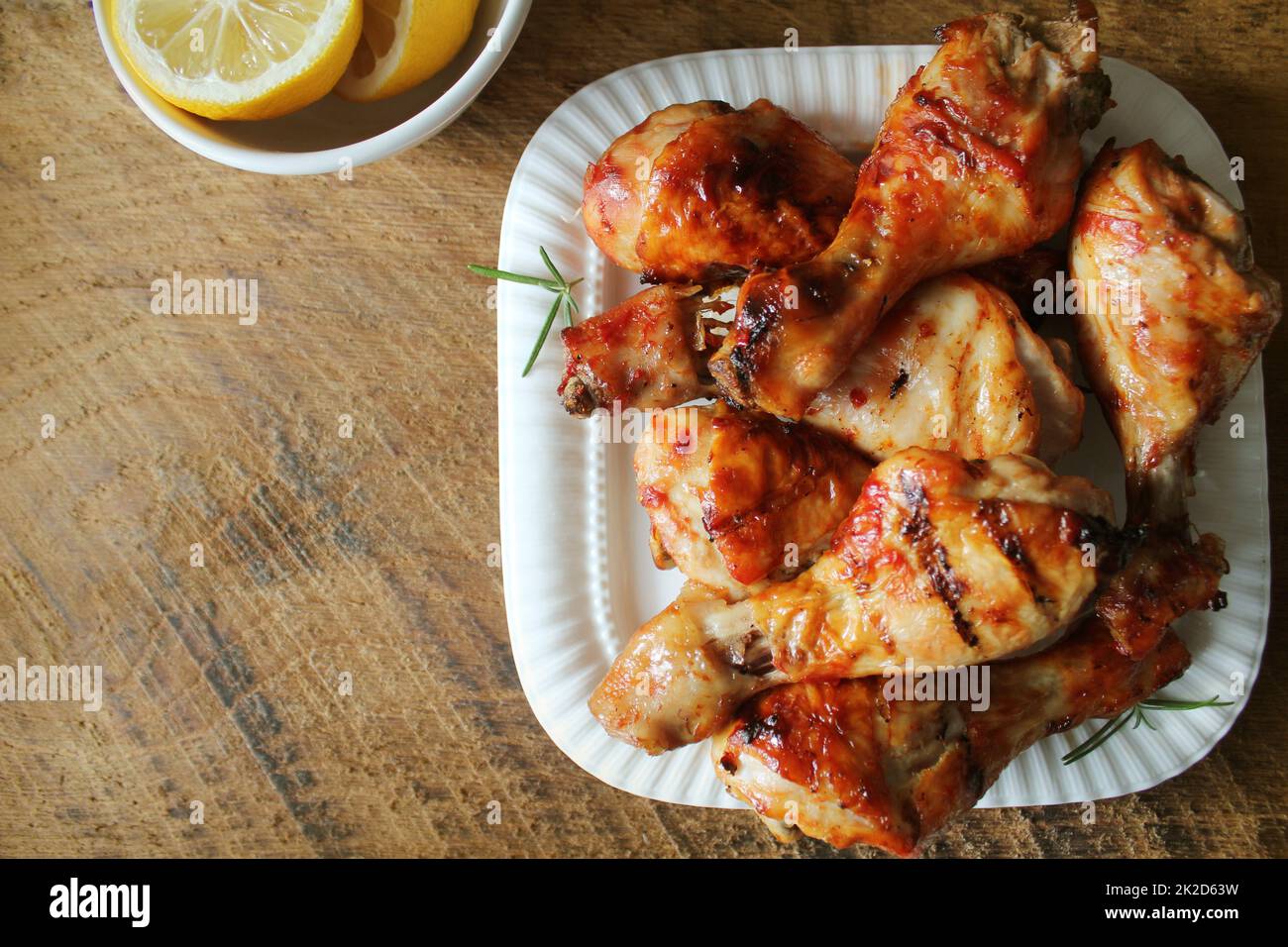 Grilled chicken legs on white plate. Rustic background Stock Photo - Alamy