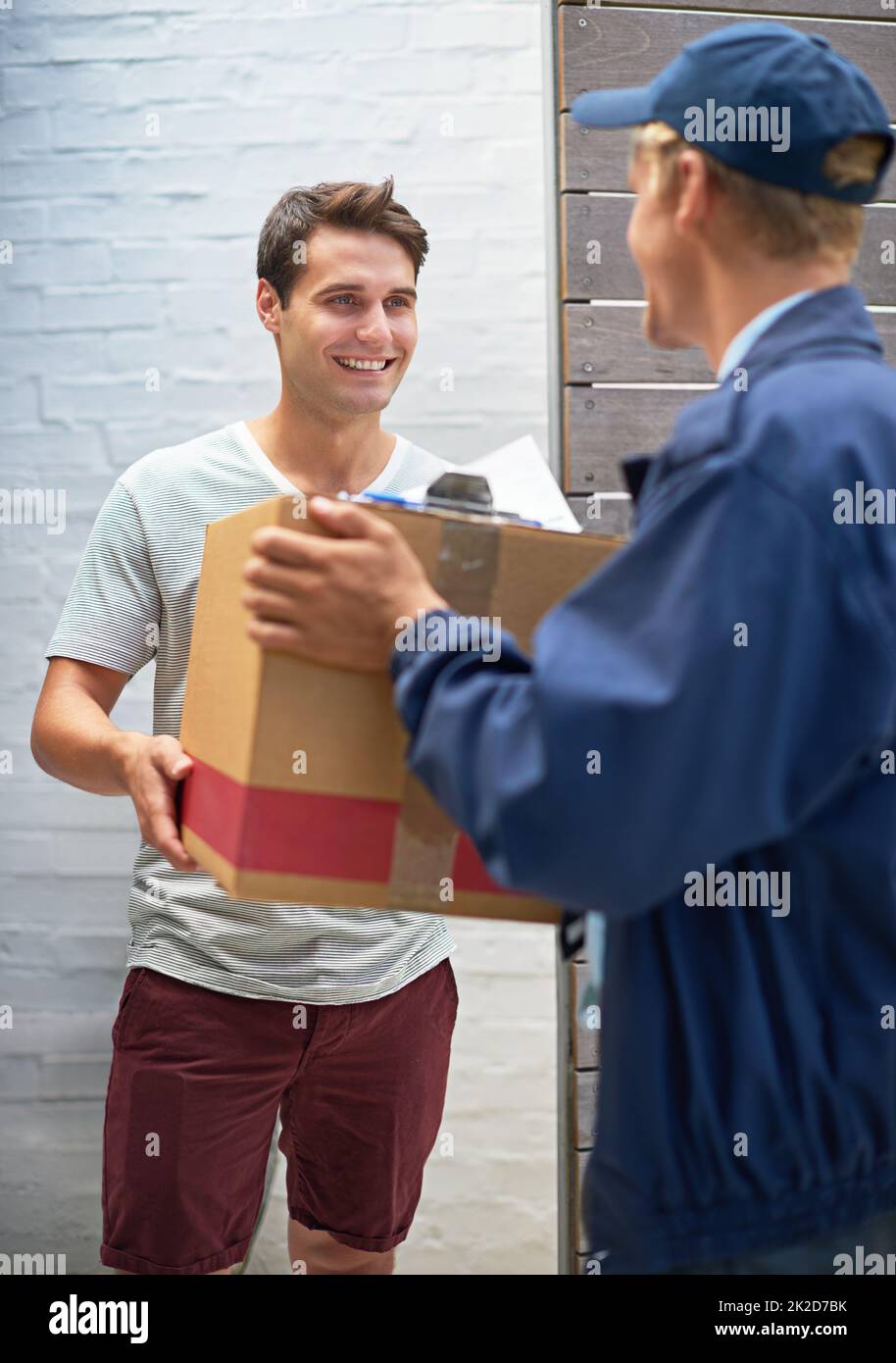 Receiving the last of his boxes. Shot of a young man receiving a ...