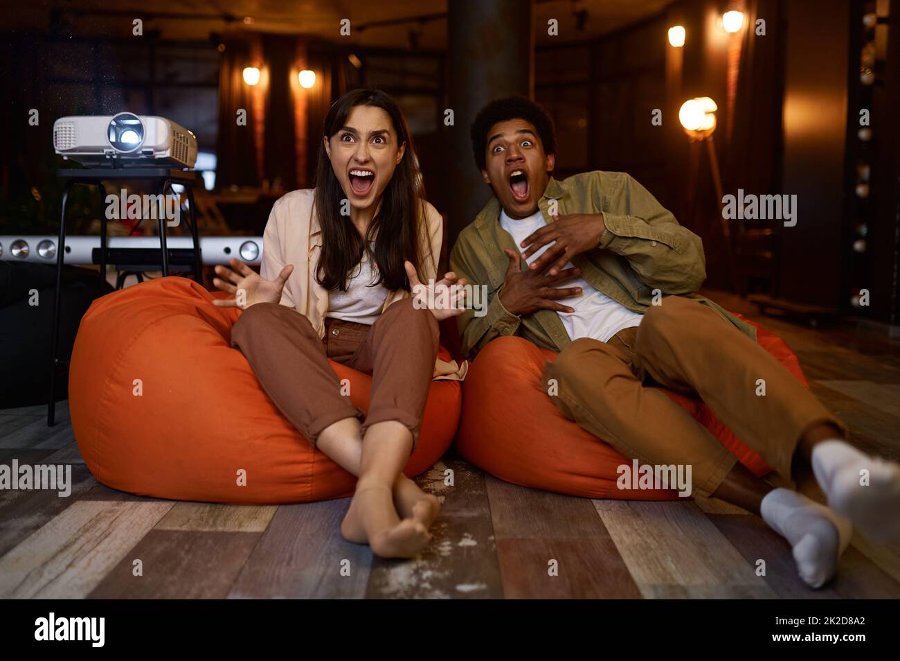 Scared couple watching horror movie at home Stock Photo - Alamy