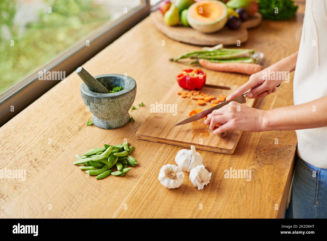 All the right cooking implements. an attractive young woman chopping ...
