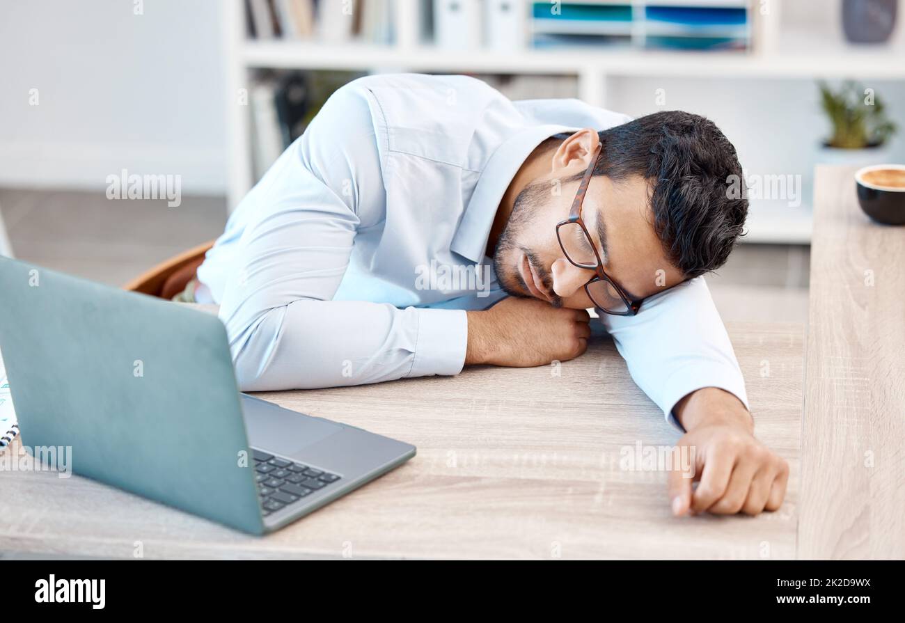 Tired, headache and sleeping worker behind laptop while lying his head ...
