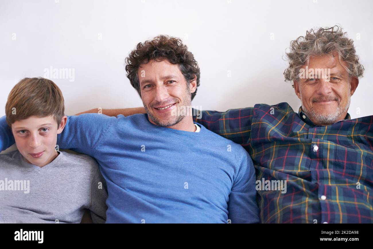 Decades of difference. Portrait of three generations of men sitting on ...