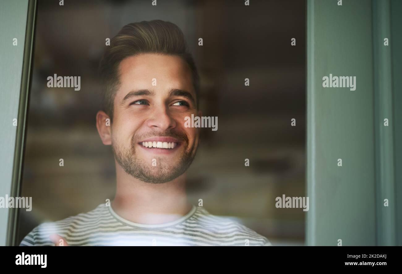 Make everyday an awesome one. Shot of a handsome young man looking out ...