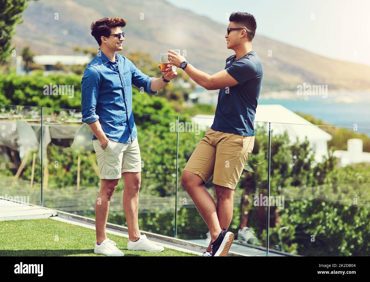 Drinks up buddy. Full length shot of two handsome young men having ...