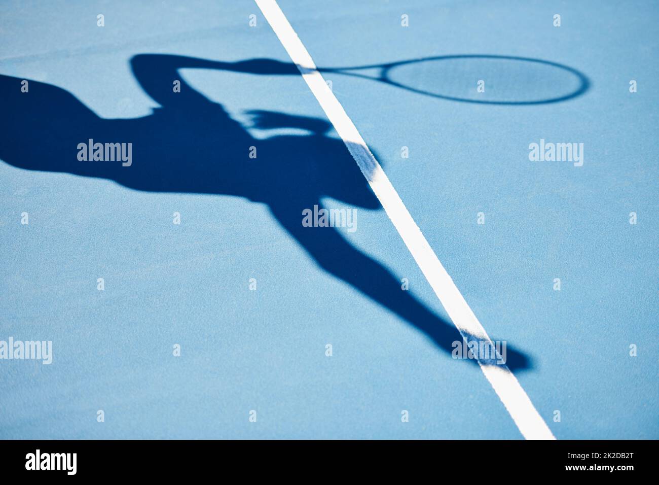 The shadow of a winner. A shadow of a tennis player ready to serve ...